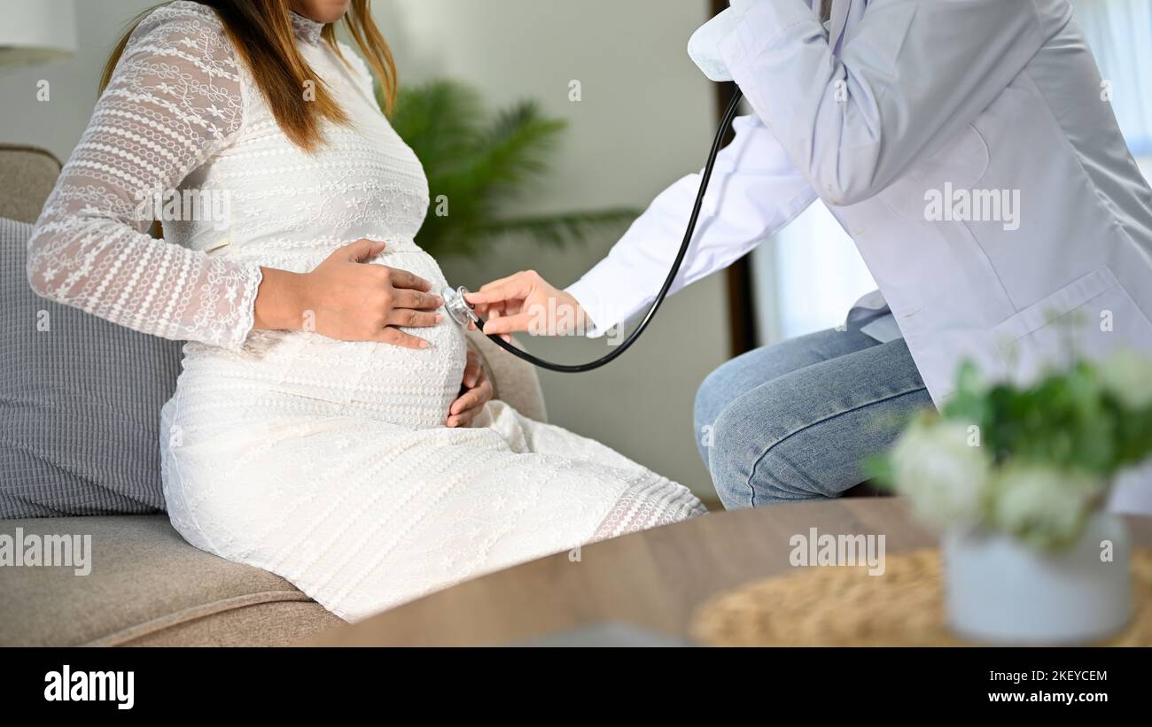 Professional Asian female doctor using a stethoscope to listen to the ...