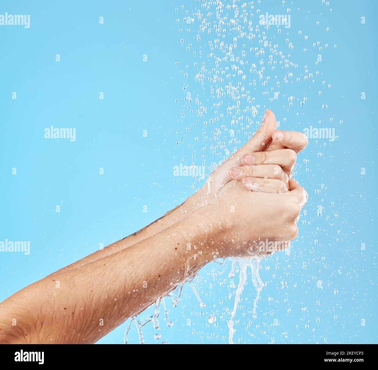 Woman, water splash or washing hands on blue background in studio for ...