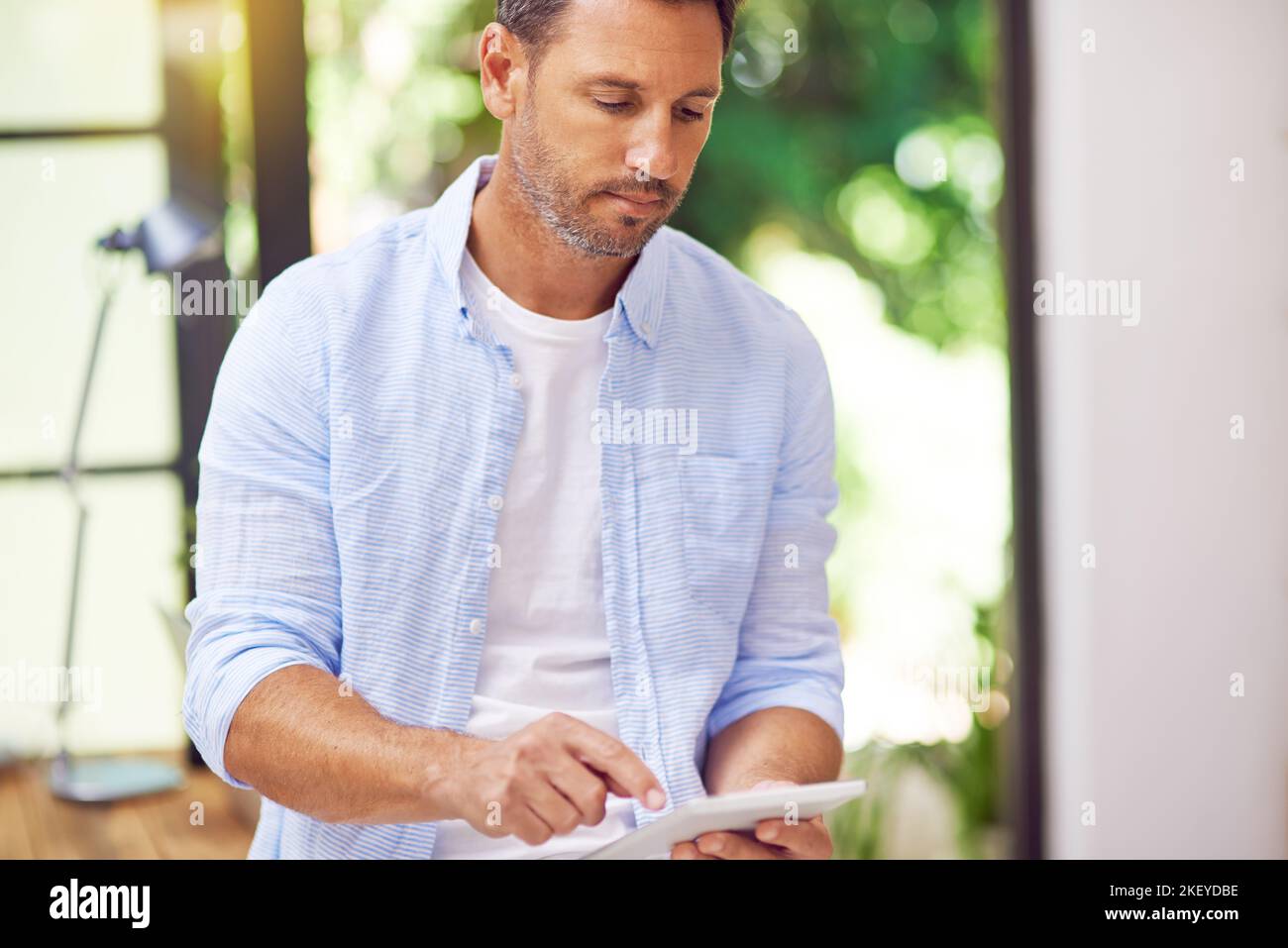 Checking his emails on the go. a young man working from home Stock ...