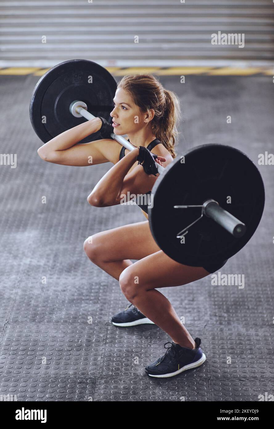 Every lift is worth it. a young woman working out with weights at the ...