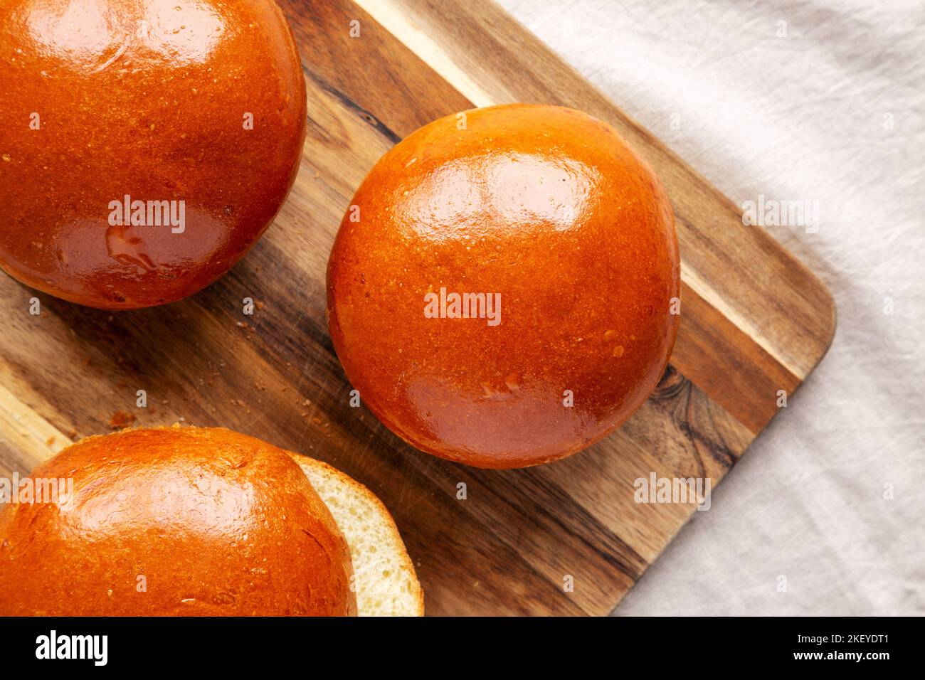 Homemade Brioche Hamburger Buns on a wooden board, top view. Flat lay ...