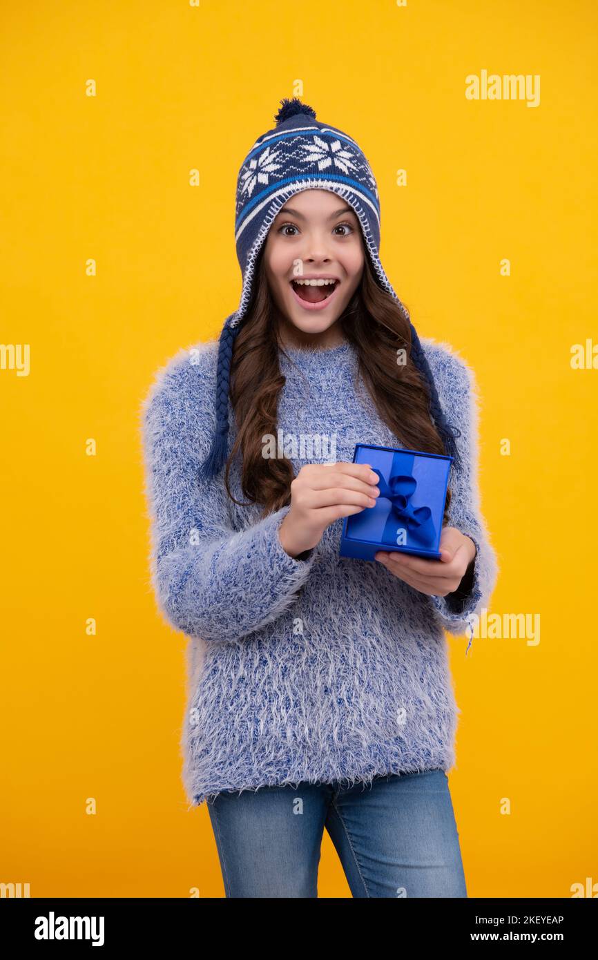 Teenager child in winter wear holding gift boxes celebrating happy New ...