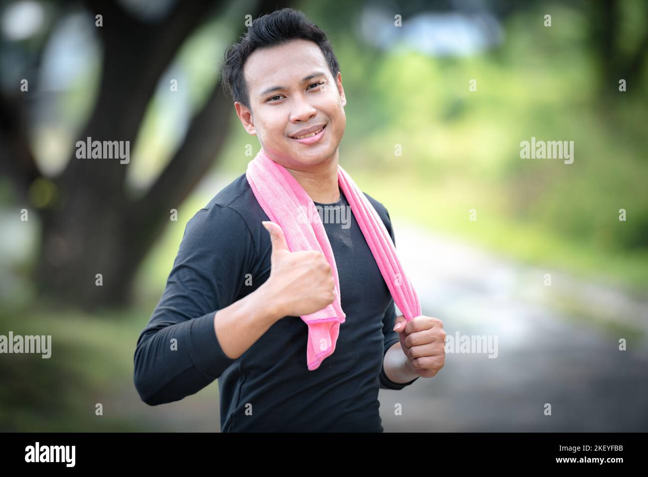 Young healthy Chinese boxing man workout in the park, looking at camera ...