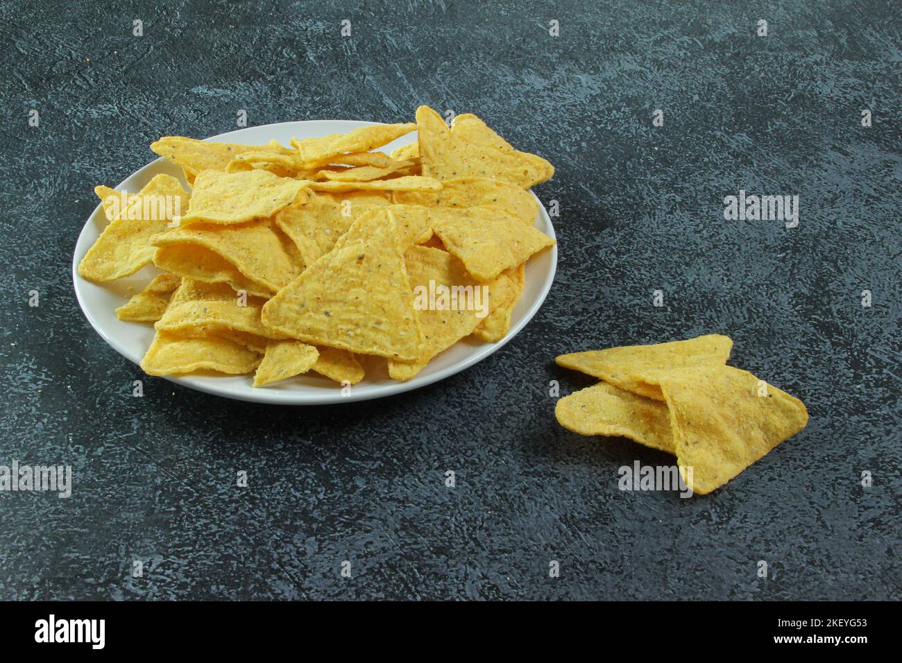 White plate with corn chips nachos on the concrete background. Mexican ...