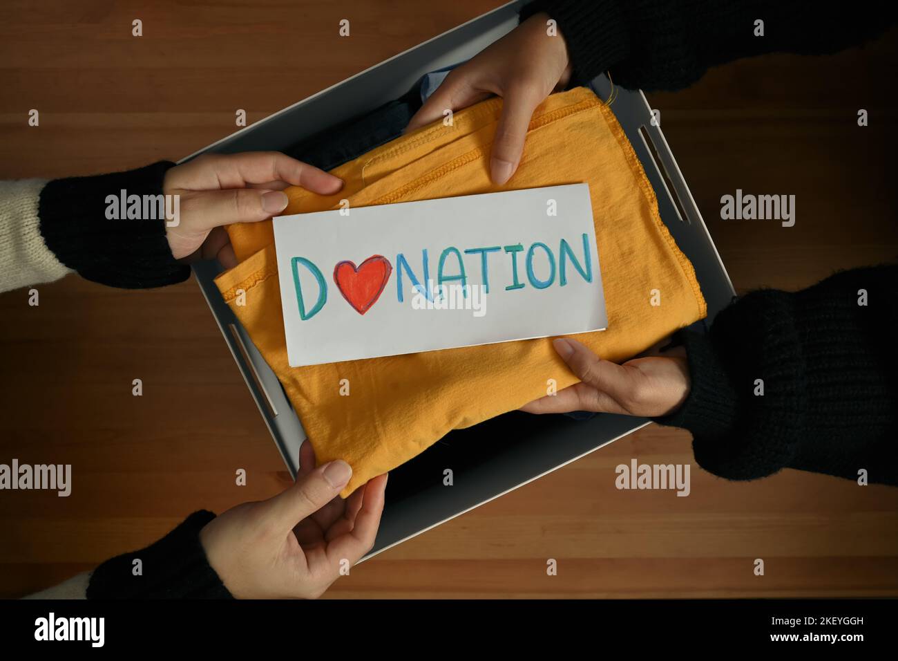 Unrecognizable people preparing used old garment into donation box ...
