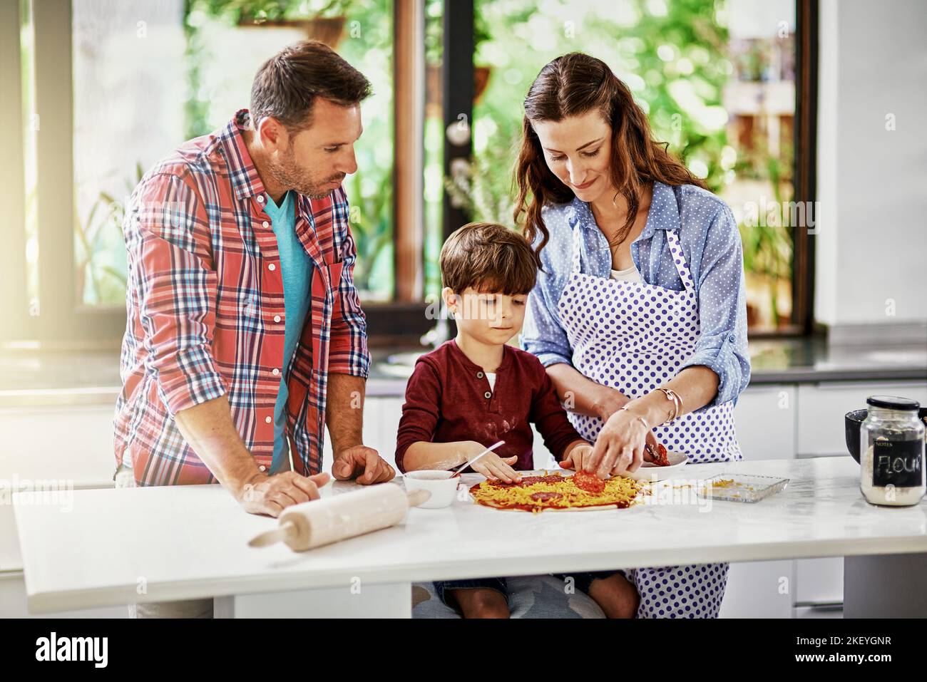We love doing things as a family. a young family making pizza together ...