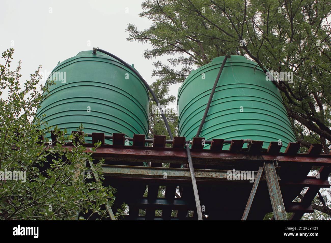Two big green plastic water storage tanks on metal stand, image taken ...