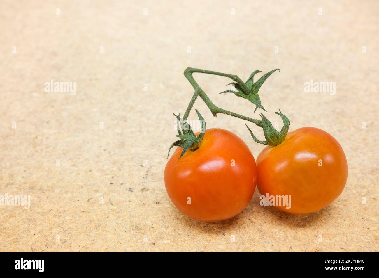 Two red cherry tomatoes on wooden background Stock Photo - Alamy