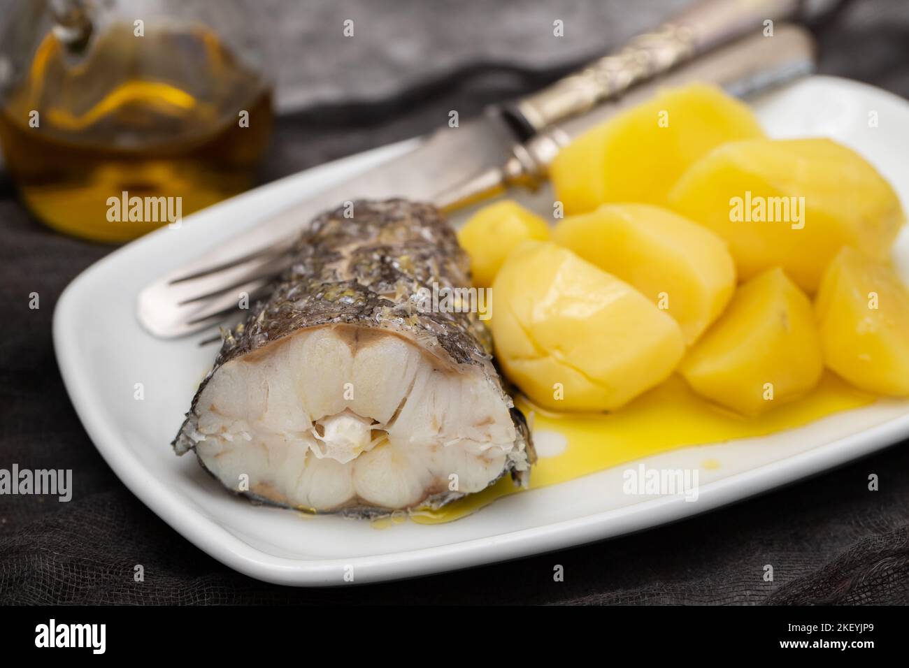 baked vegetables with boiled fish on white plate on blue Stock Photo ...