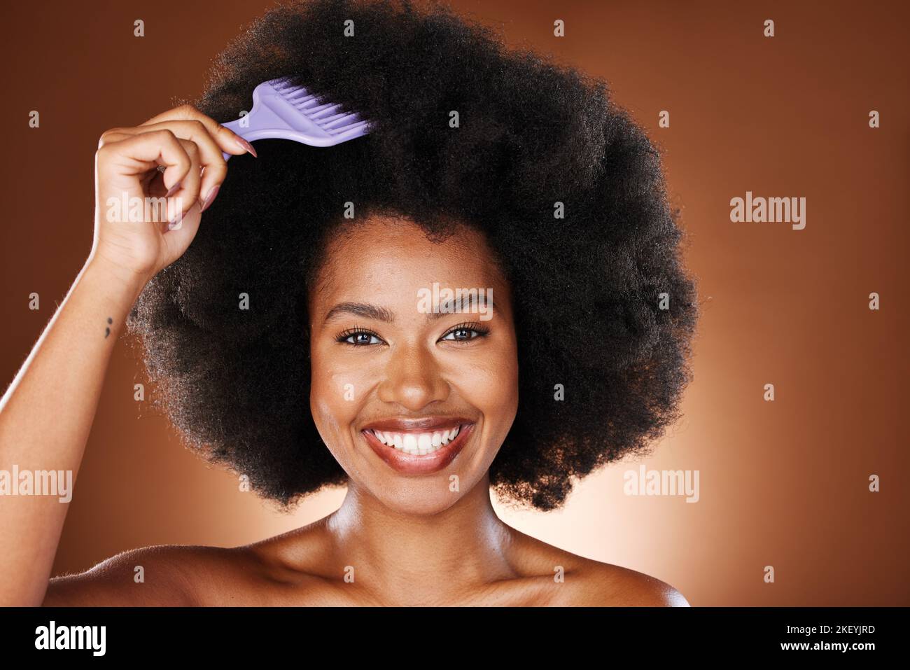 Hair care, beauty and black woman with comb in afro smiling in studio ...
