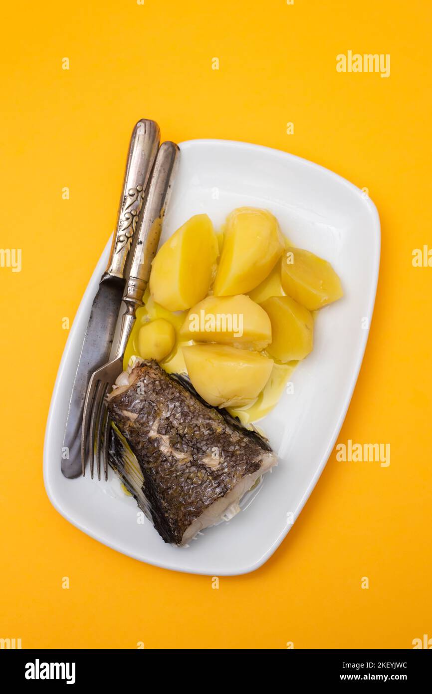 baked vegetables with boiled fish on white plate on blue Stock Photo ...