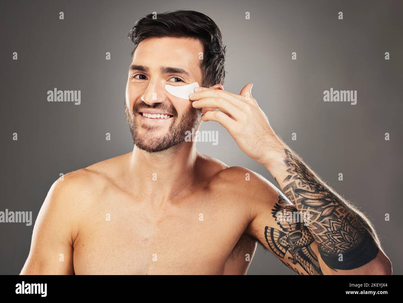 Skincare, face and man with eye patch on a gray studio background ...