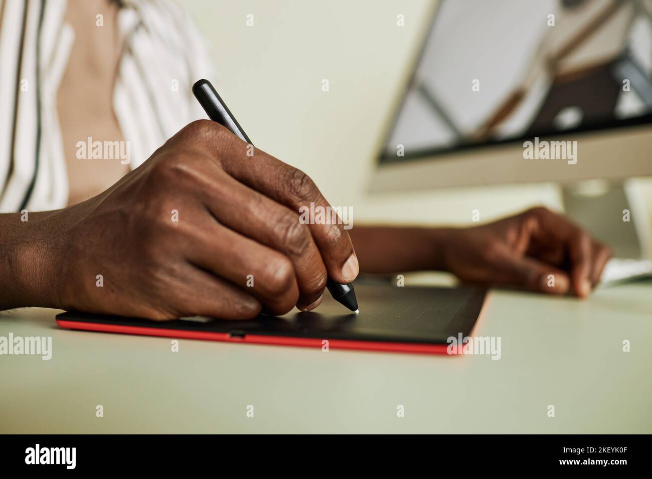 Hand of young African American designer of digital drawing using ...