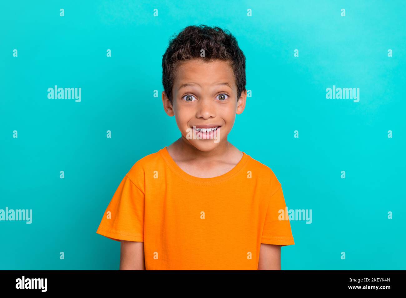 Photo of good mood excited little guy dressed orange t-shirt smiling ...