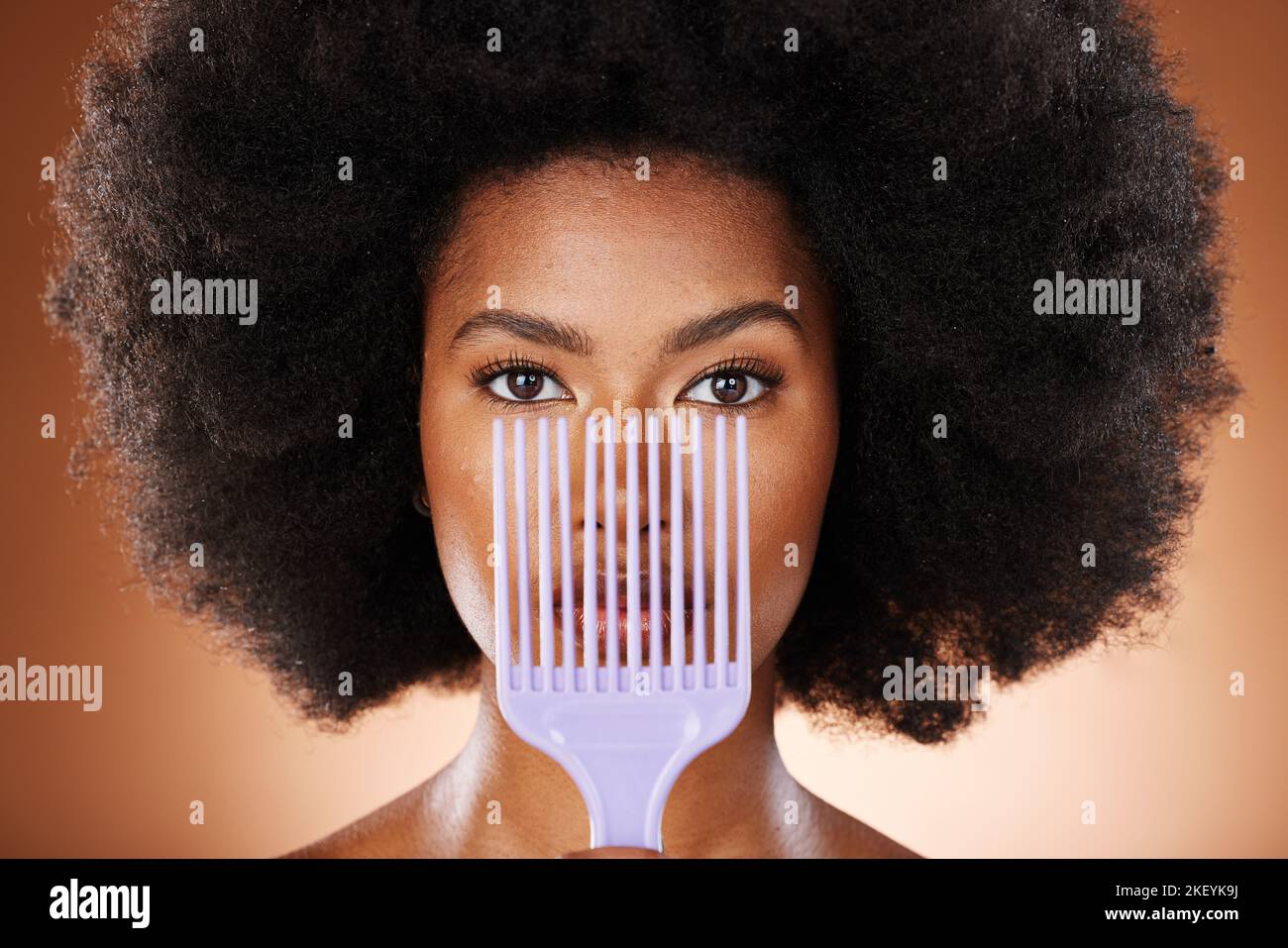 Beauty, hair care and black woman with an afro comb in a studio ...