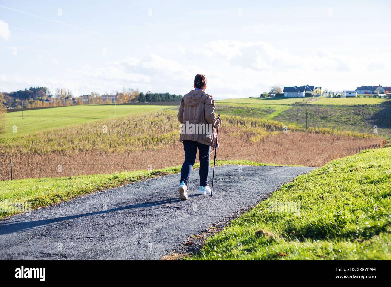 Elder lady nordic walking on countryside road Stock Photo - Alamy