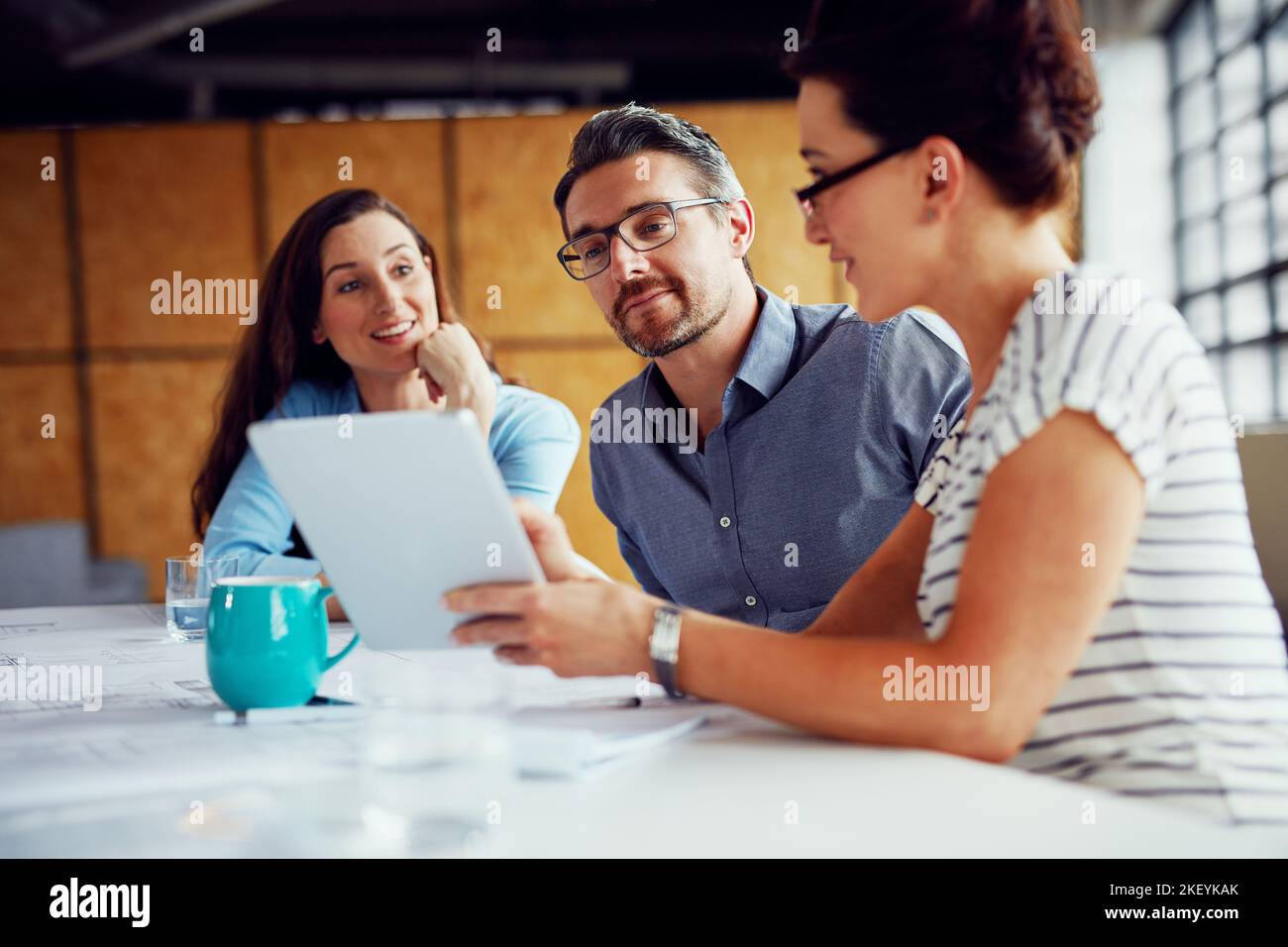 Using technology to visualize their ideas. a group of designers using a ...