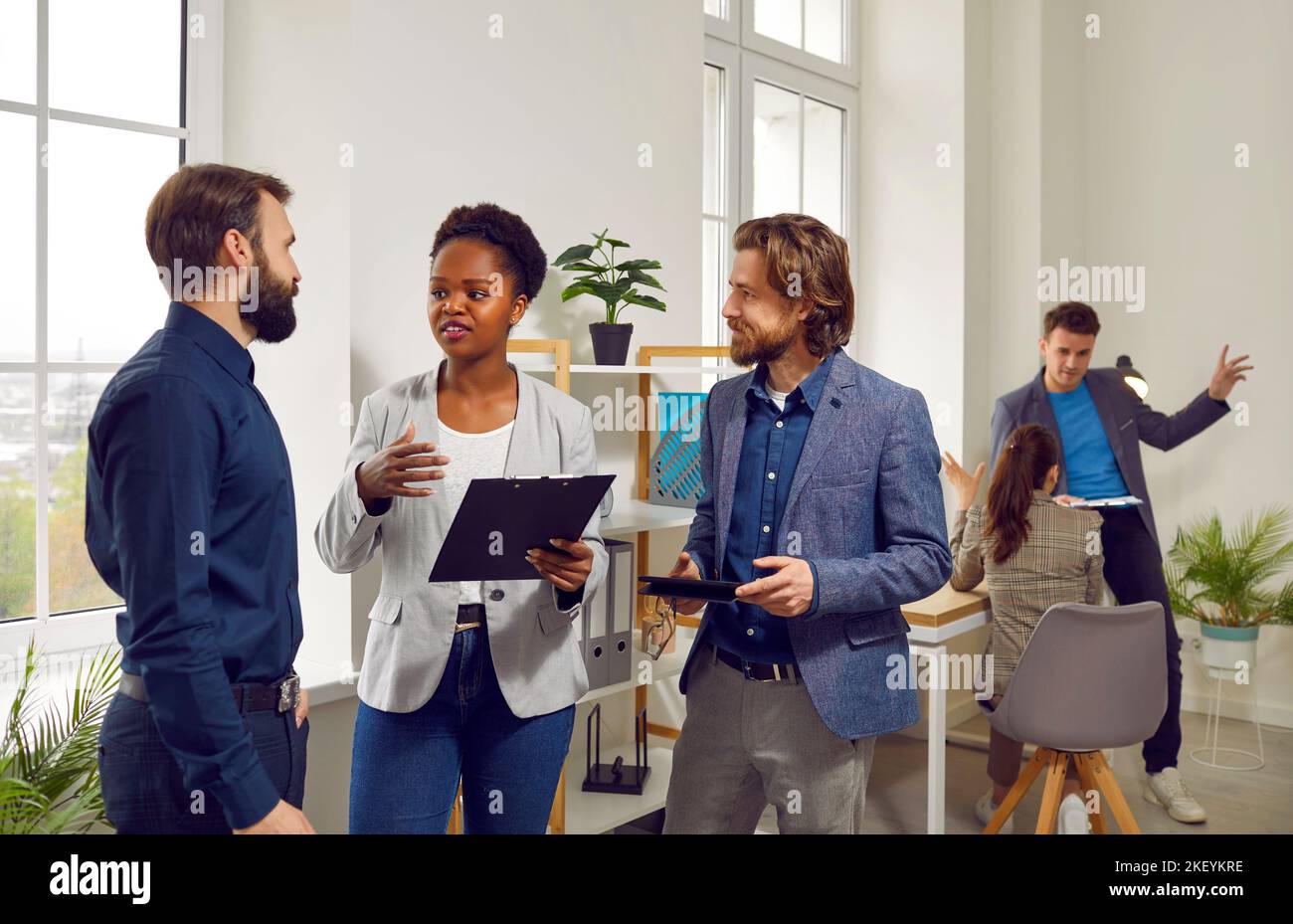 Three work colleagues are discussing joint business project together at ...