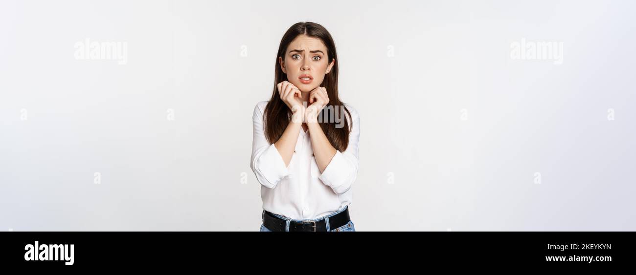 Portrait of brunette woman looking concerned, worried and shocked ...