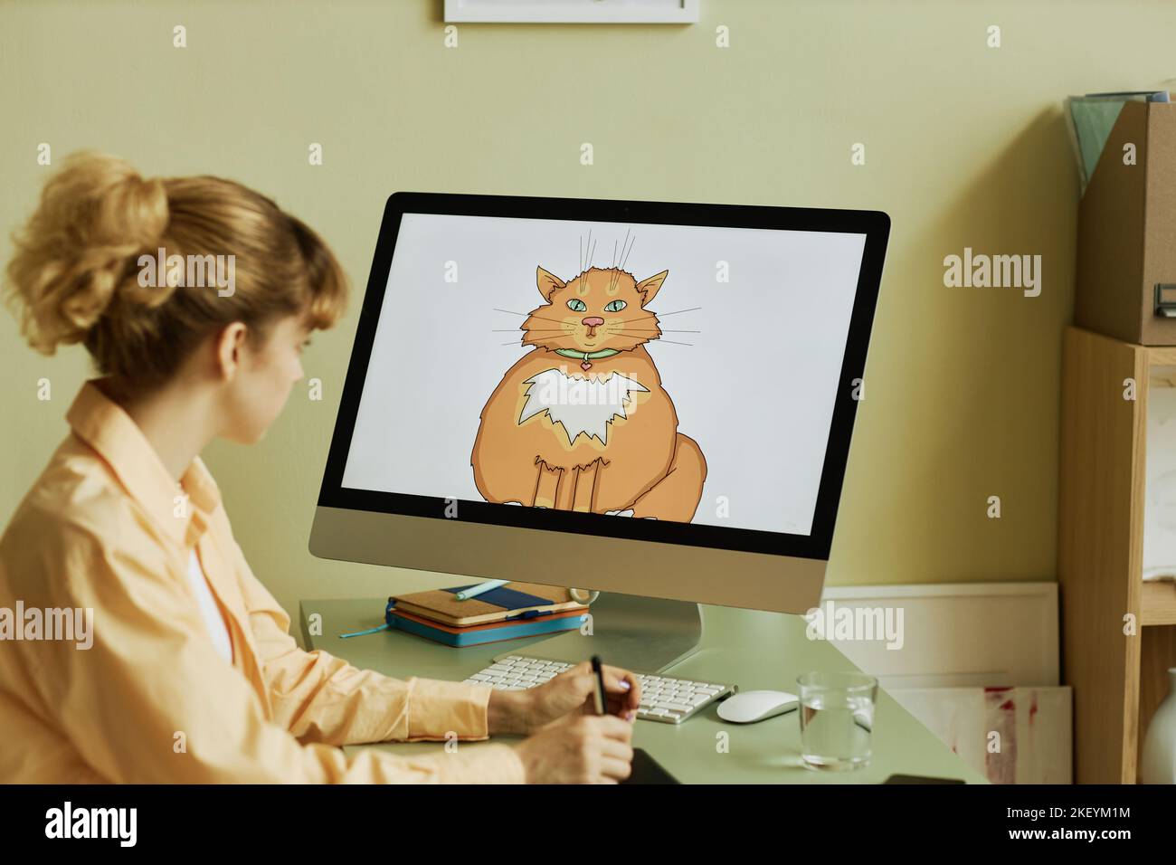 Focus on computer screen with fat ginger cat drawn by digital artist ...
