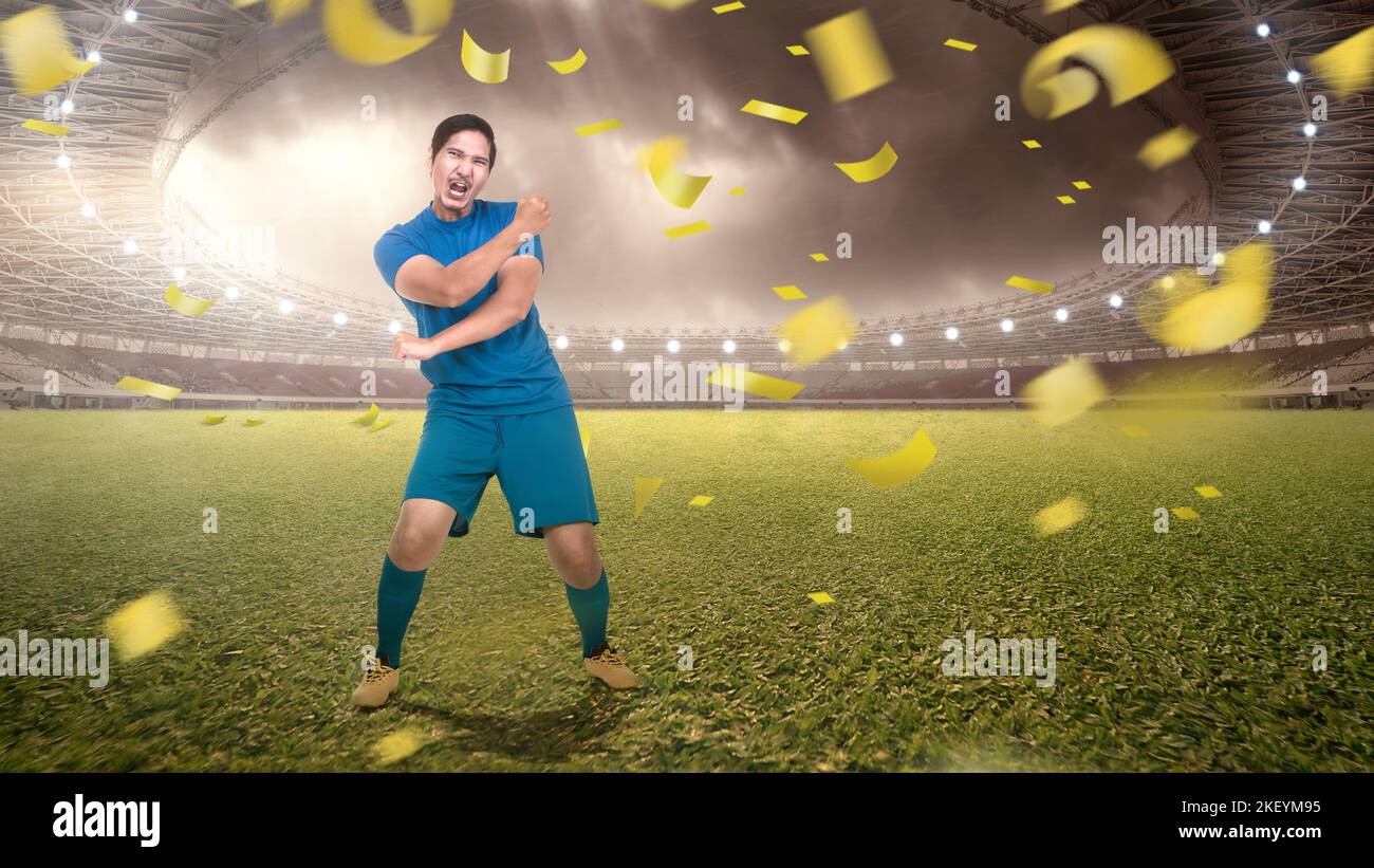 Asian football player man in a blue jersey celebrates the victory on ...