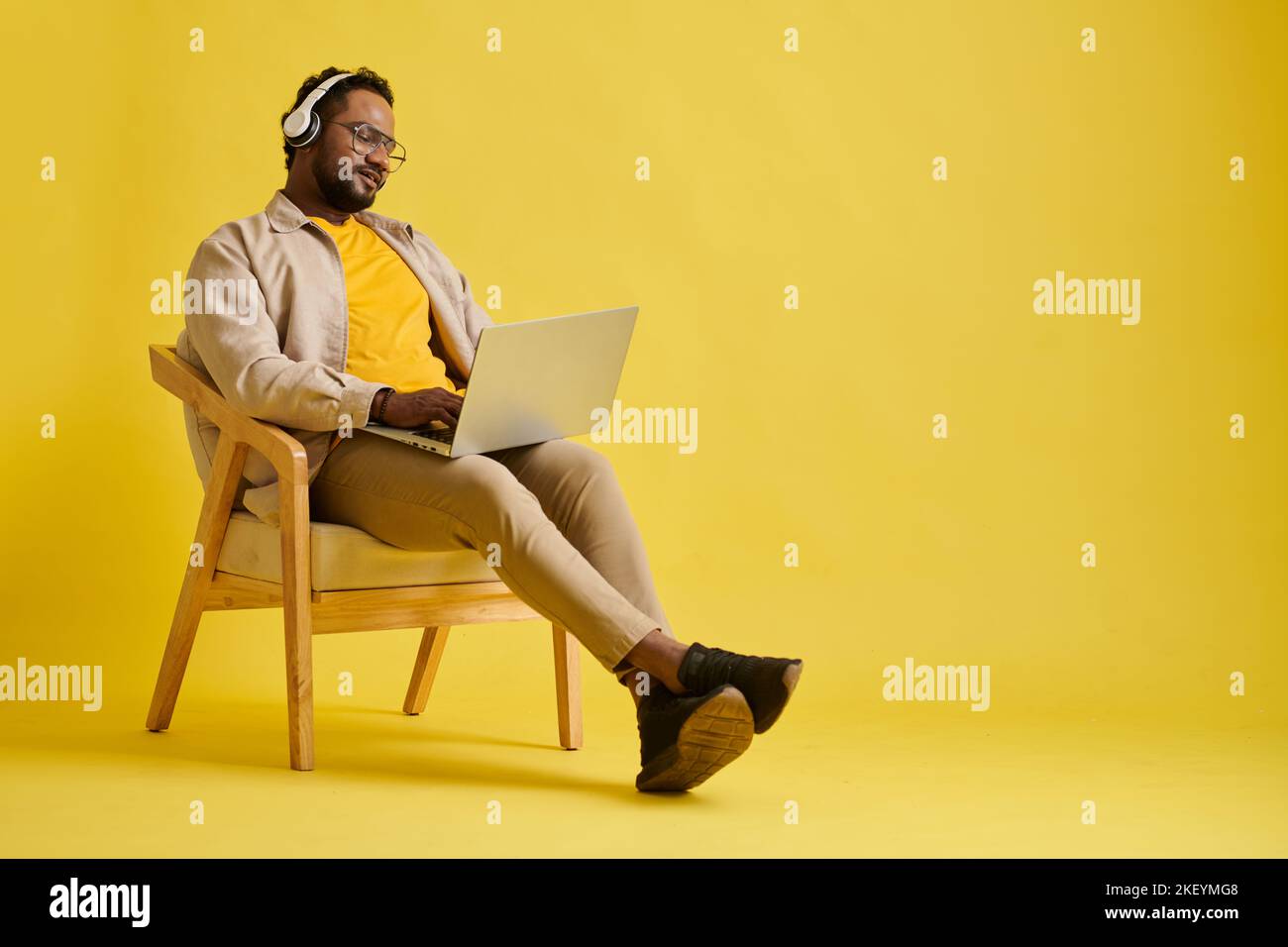 Software developer listening to music in headphones and working on ...