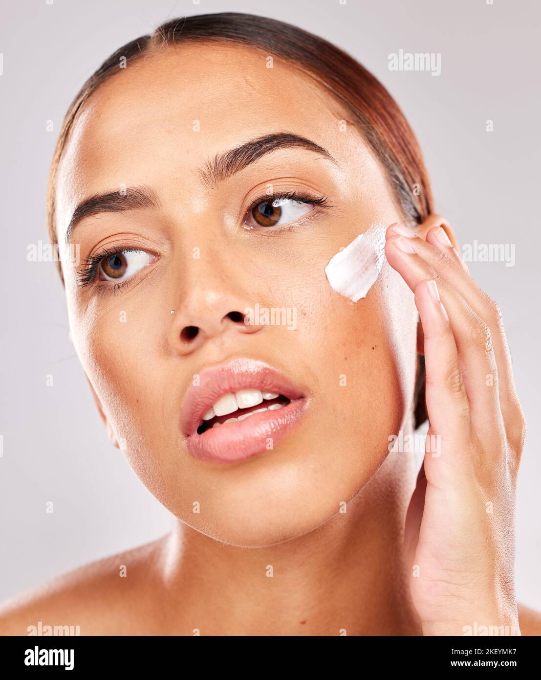 Face, beauty and skincare with a model black woman using moisturizer on ...