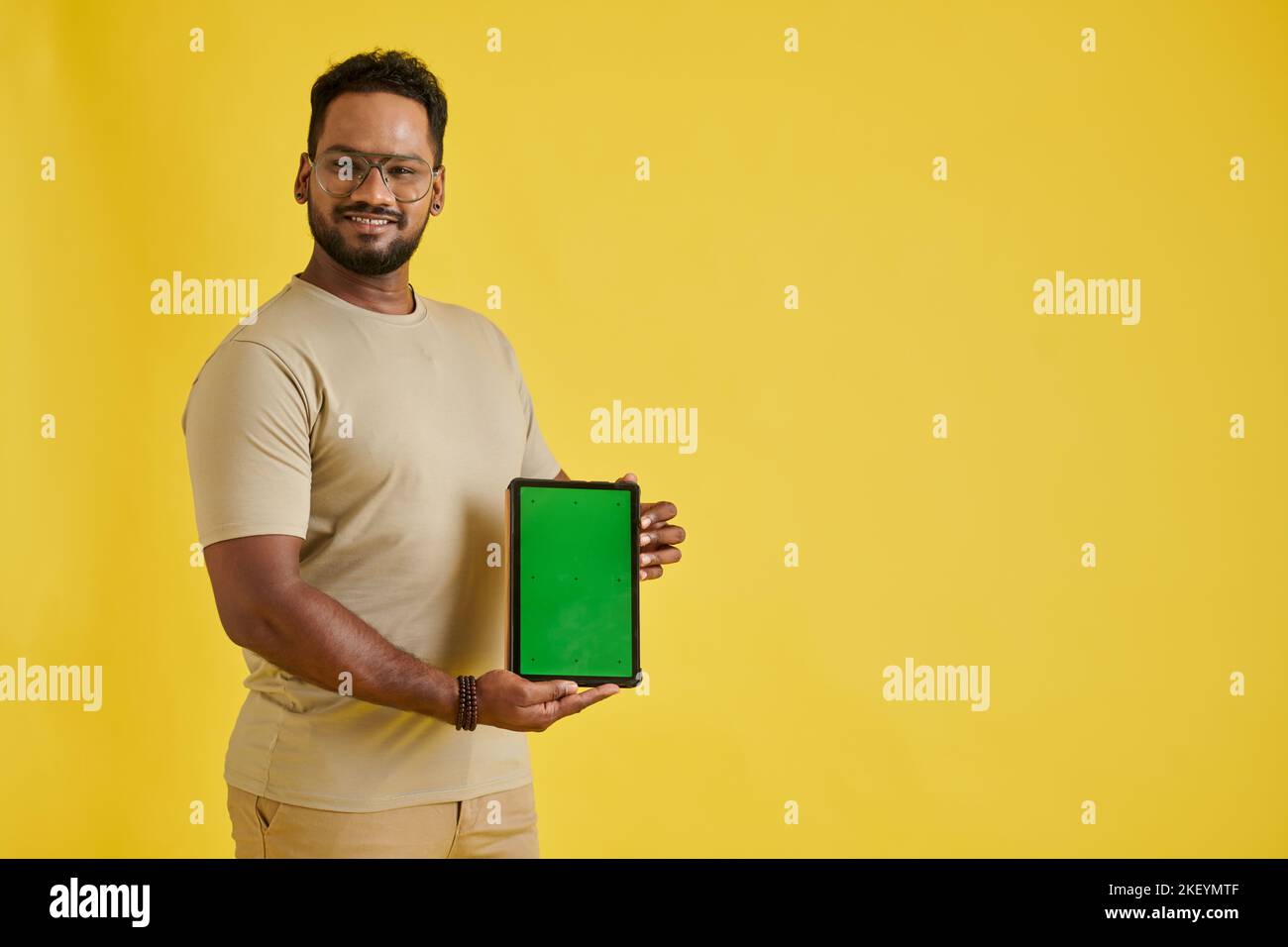 Excited software developer showing digital tablet with green screen ...