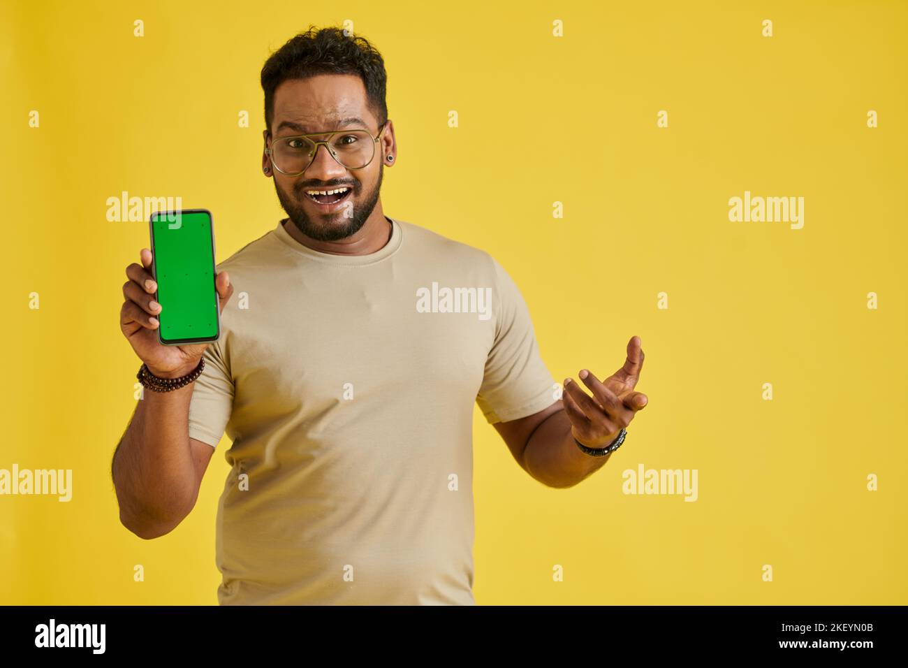 Portrait of happy excited developer showing smartphone with mobile ...