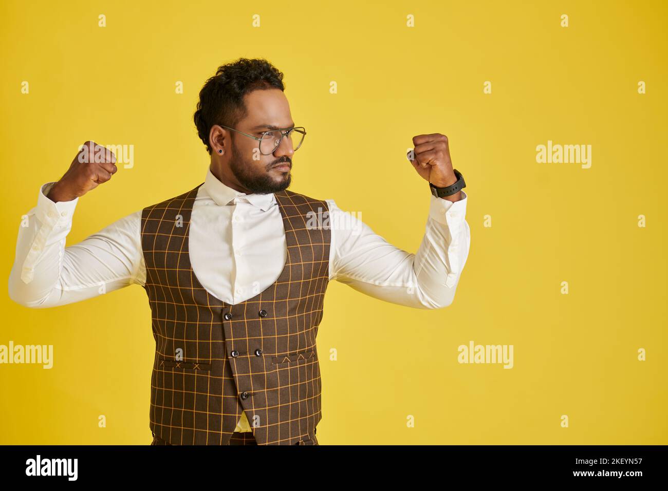 Serious businessman flexing biceps muscles demonstrating his strength ...