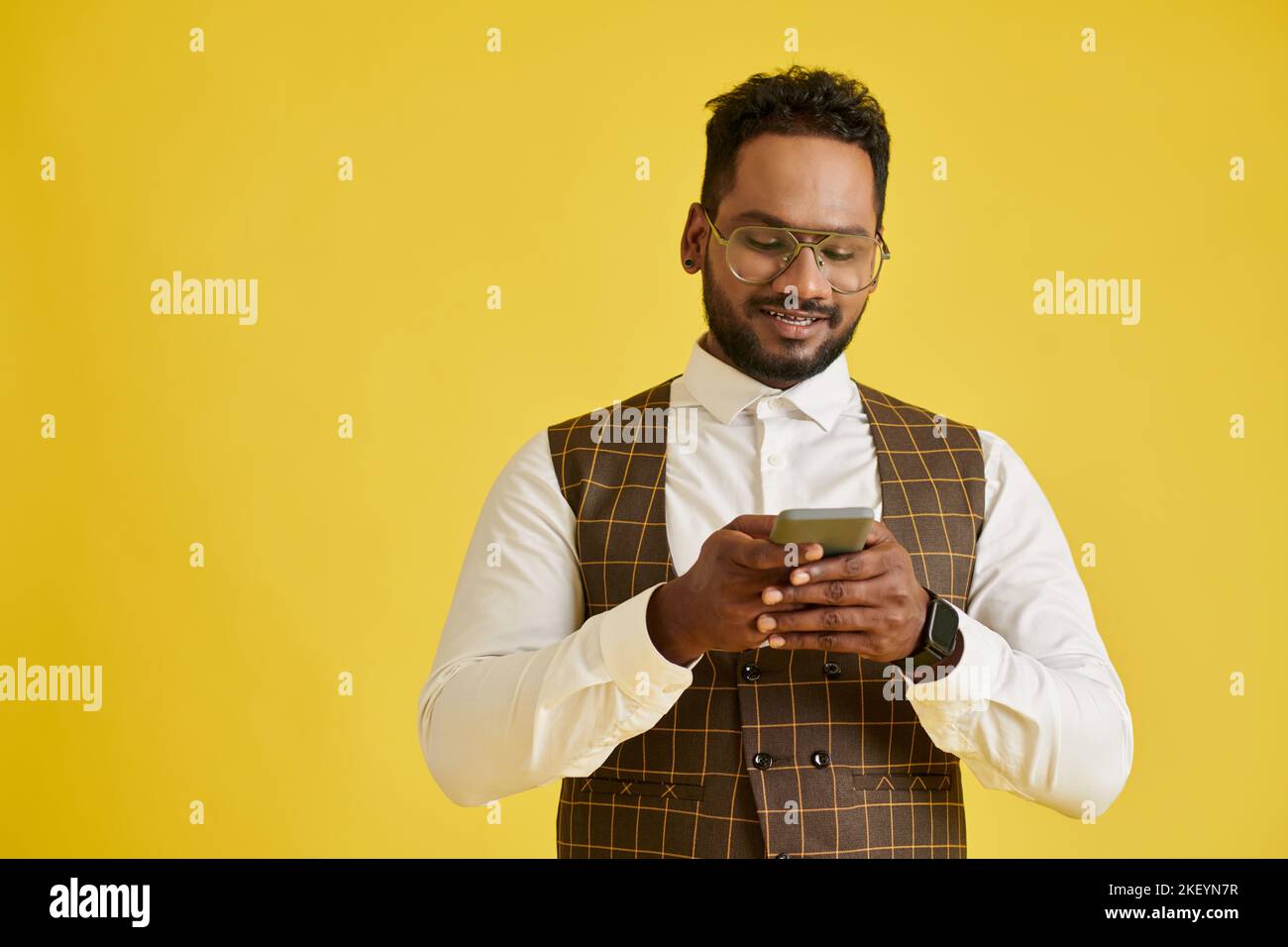 Studio portrait of happy man answering text message from the beloved ...