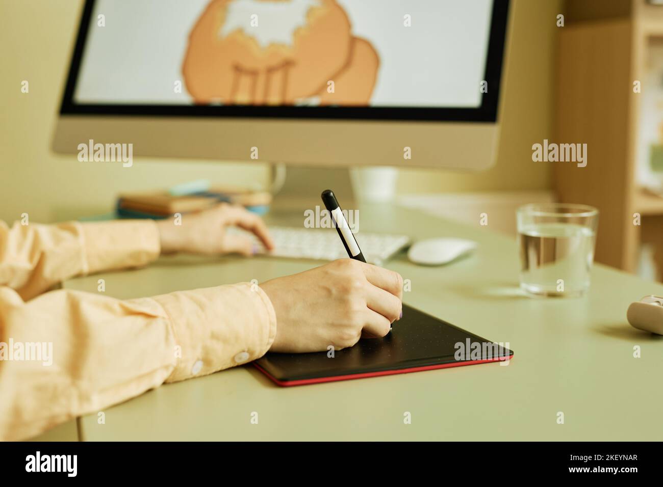 Hand of creative digital artist with stylus drawing in tablet screen ...