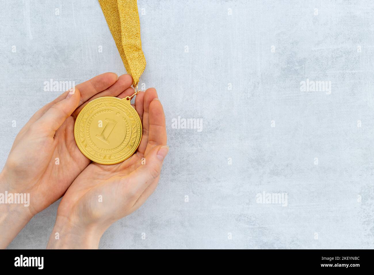 Hand holding up gold medal first place. Winner concept Stock Photo - Alamy