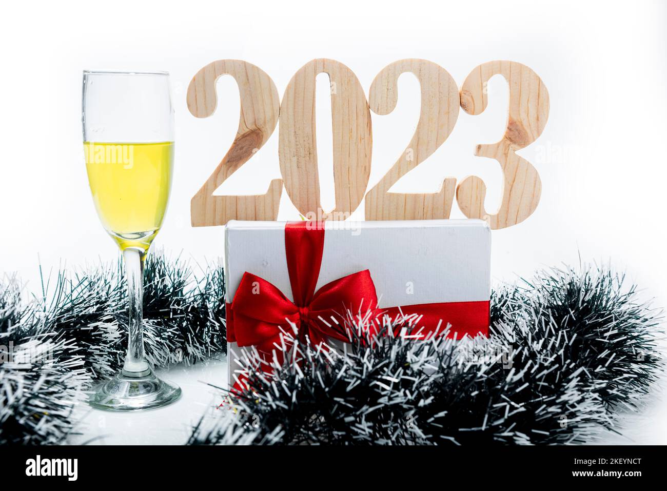 2023 with a glass of champagne and gift box with a white background ...