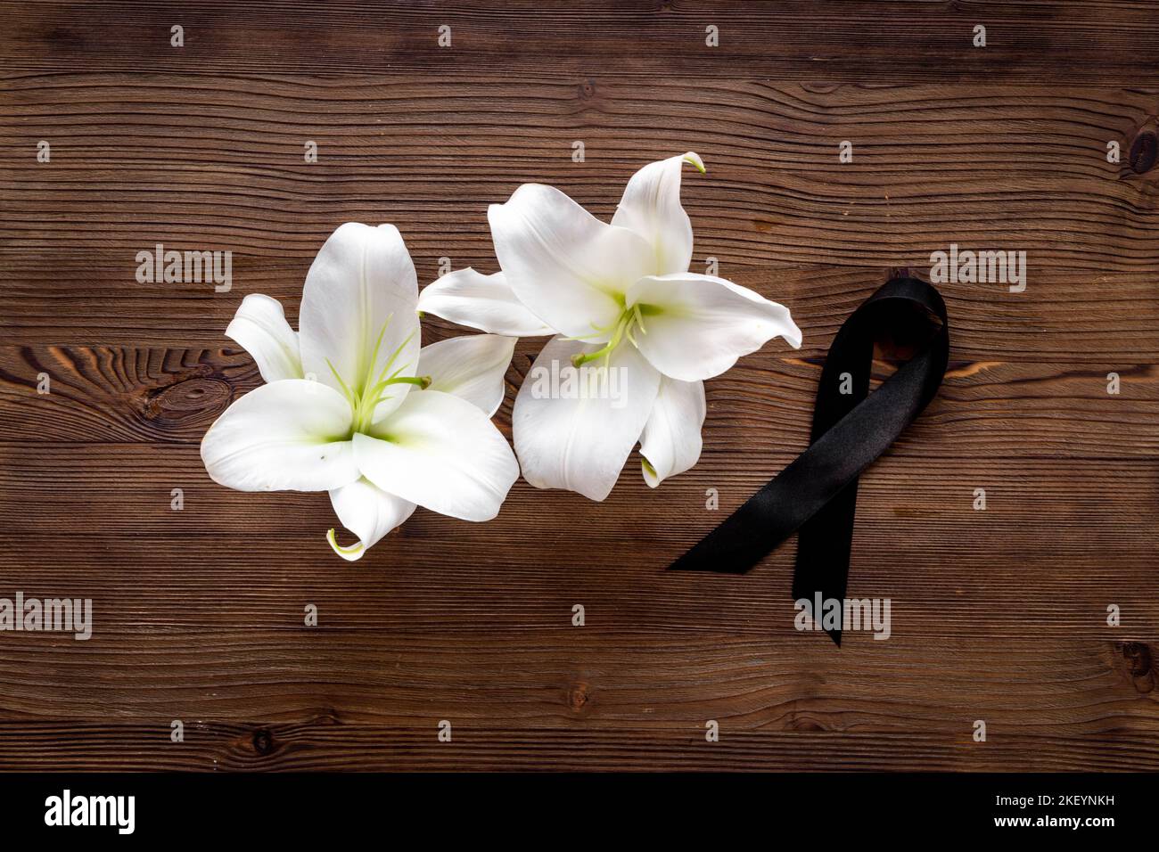 White liles flowers and black ribbon as symbol of the funeral. Mourning ...