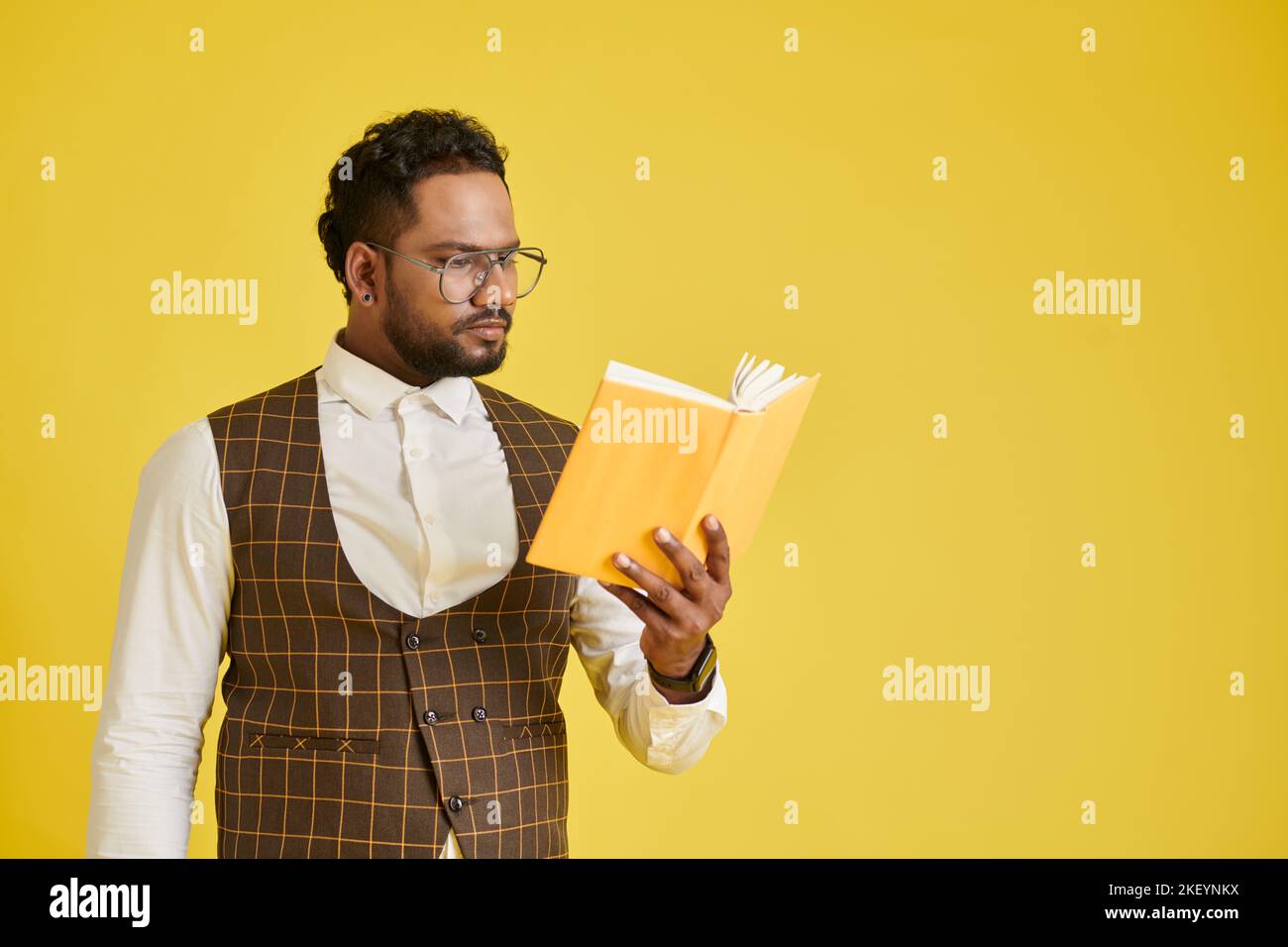 Studio portrait of concentrated man reading captivating book Stock ...