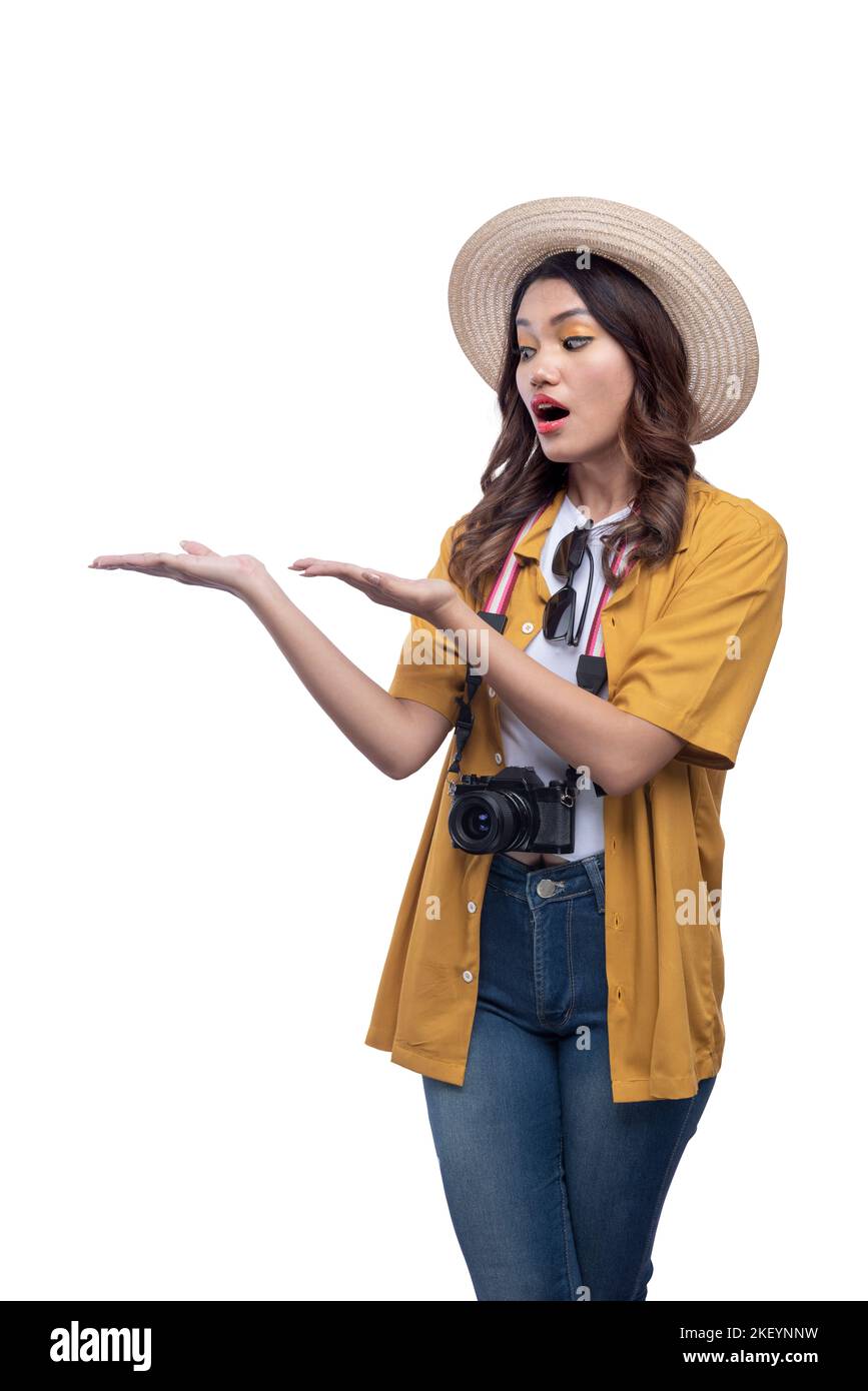 Asian woman with a hat and camera with open palm pointing at something ...