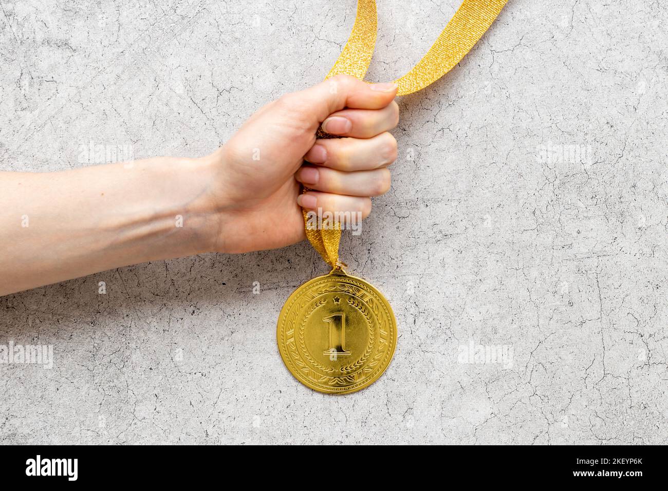 Hand holding gold medal first place. Winner of competition concept ...