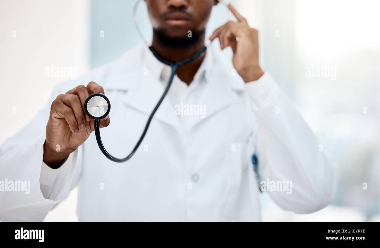 Black man doctor, stethoscope in hand and health with medical and check ...
