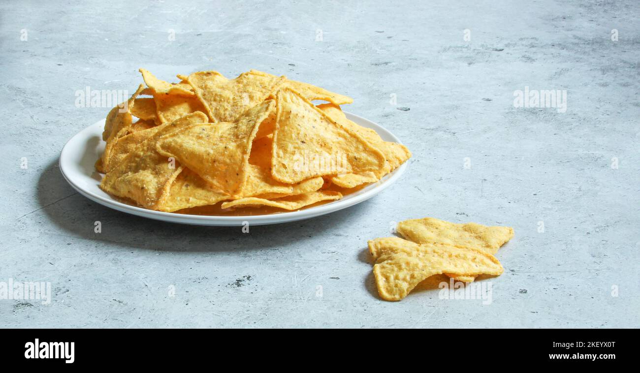 White plate with corn chips nachos on the concrete background. Mexican ...