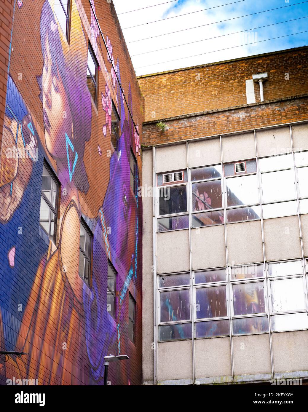 A vertical low-angle of Belfast office block covered in street art ...