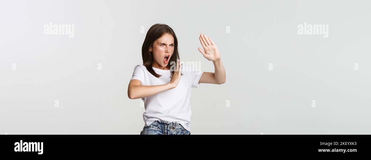 Sassy young woman standing in fighting pose to protect herself from ...