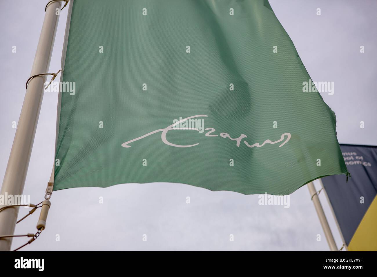 Wrinkled green flag waving in the wind with name logo of Erasmus ...