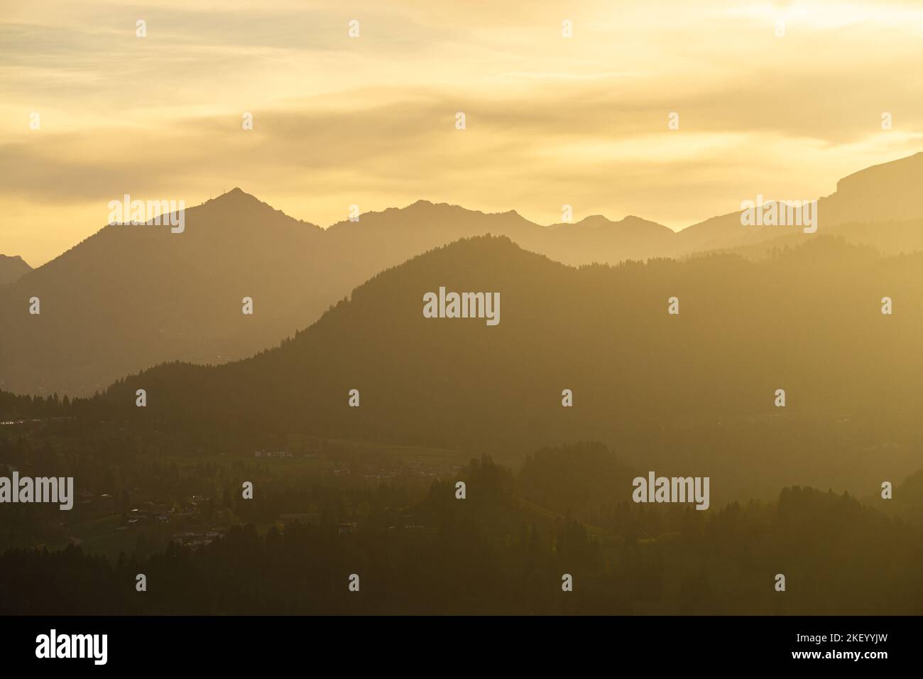 Spectacular view of mountain ranges silhouettes with yellow sunlight ...