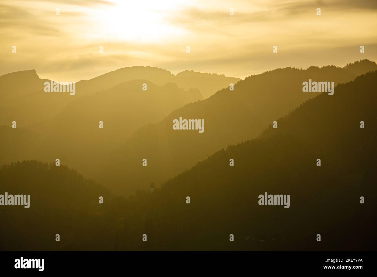 Spectacular view of mountain ranges silhouettes with yellow sunlight ...