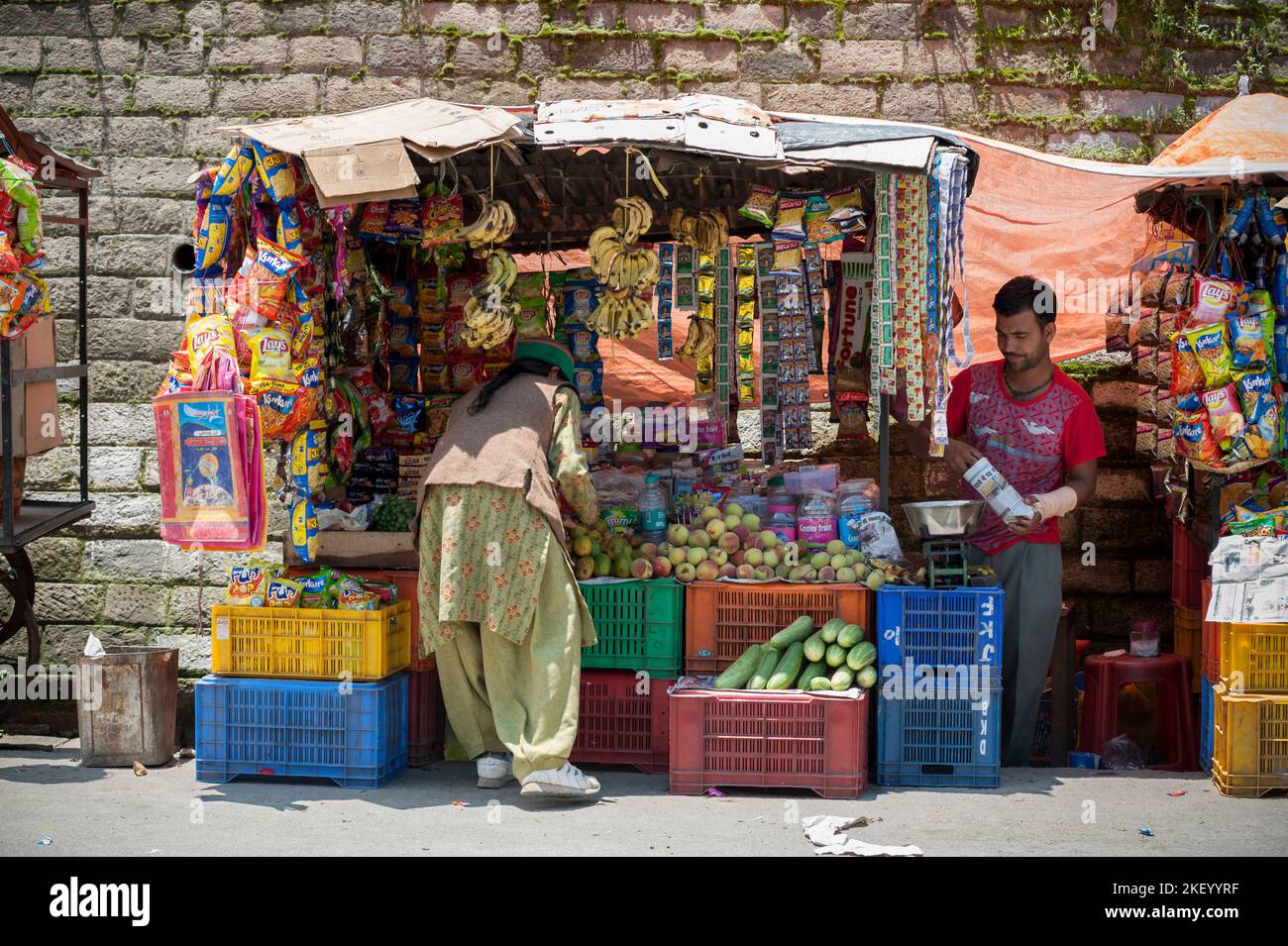 Woman customer buying some stuff at a street shop on roadside of a city ...