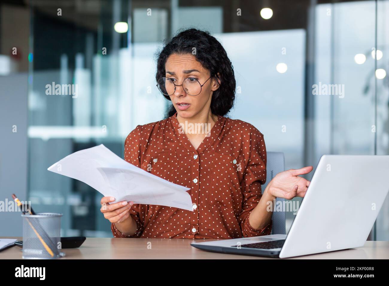 Frustrated and sad business woman holding financial report in hands ...