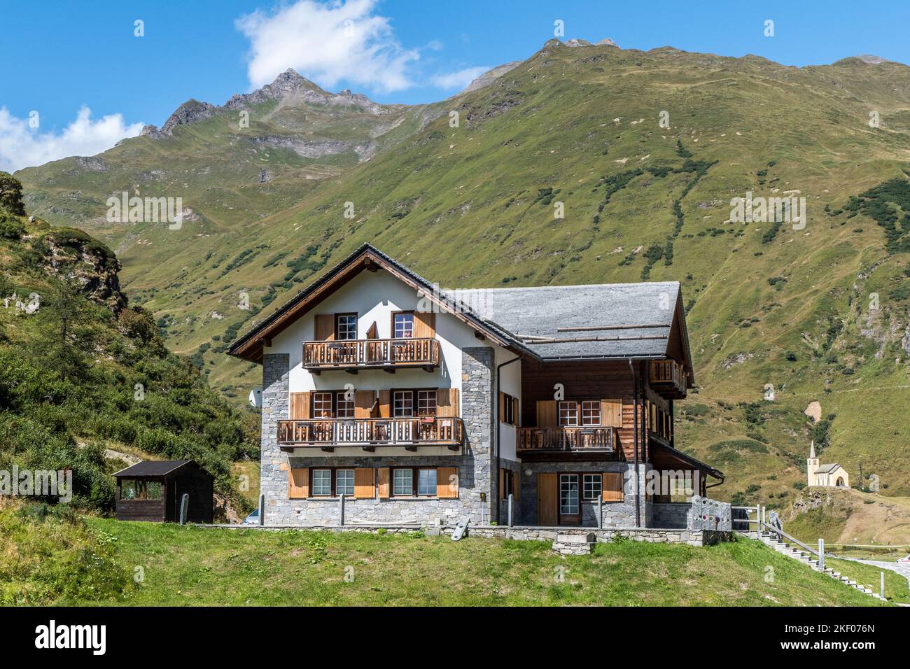 small village in the mountains with stone houses, flowers and a river ...
