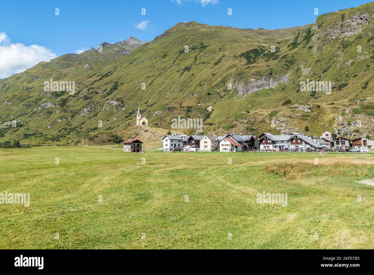 small village in the mountains with stone houses, flowers and a river ...