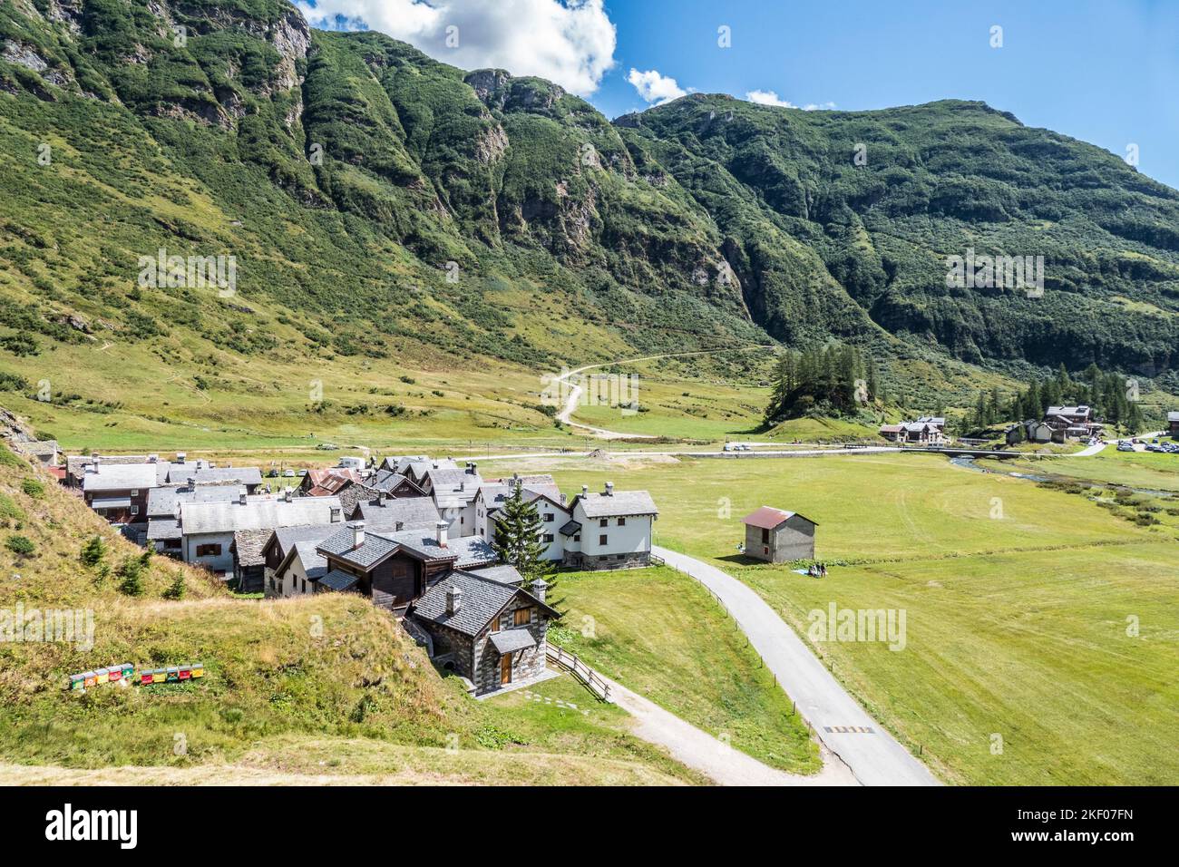 small village in the mountains with stone houses, flowers and a river ...